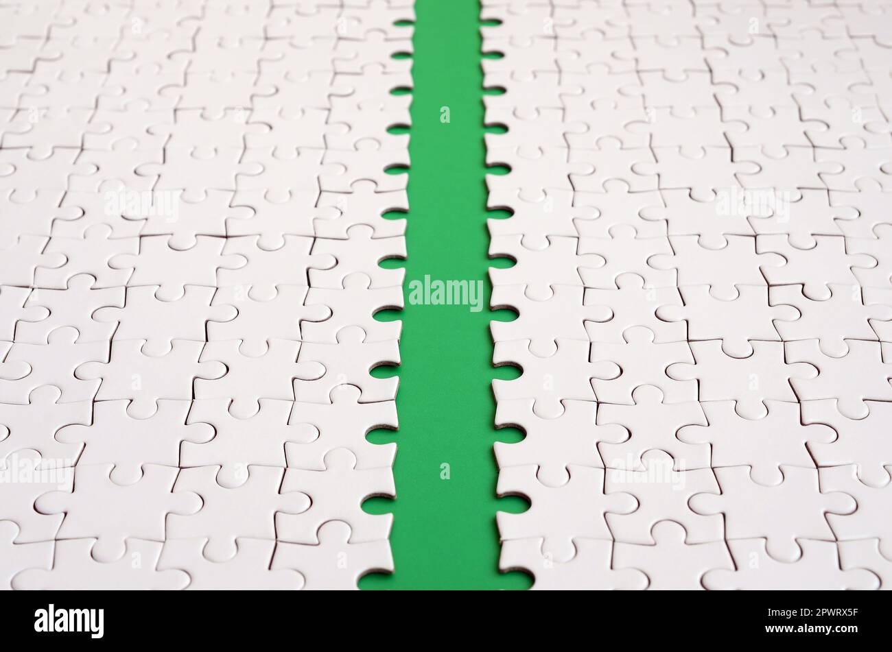 The green path is laid on the platform of a white folded jigsaw puzzle ...