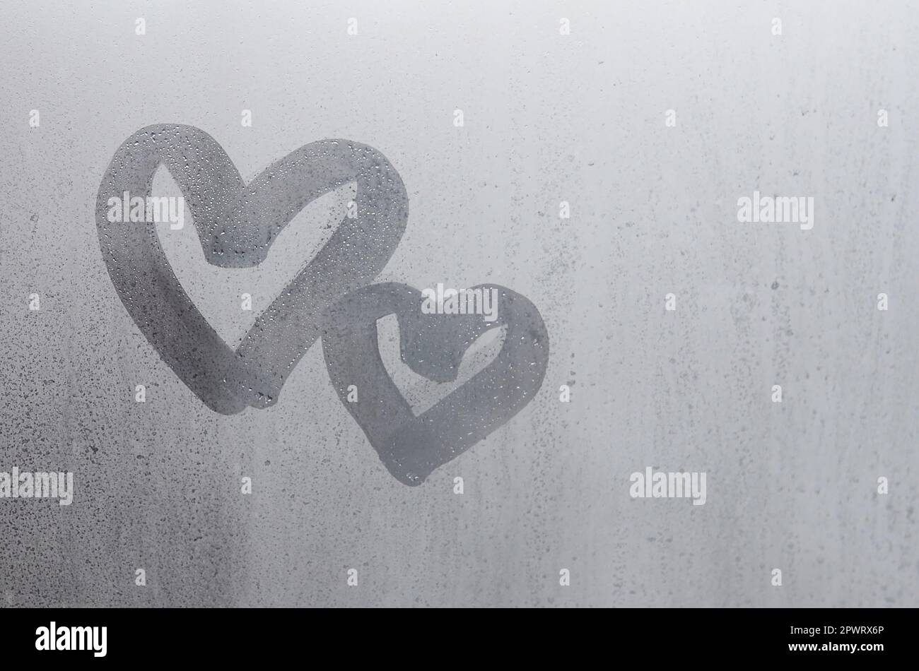 Couple of abstract blurred love heart symbol drawn by hand on the wet ...