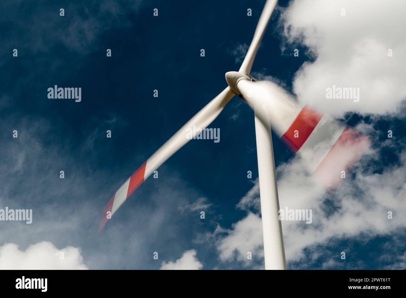 The rotor blades of a wind turbine, blurred by the rotation, in the ...