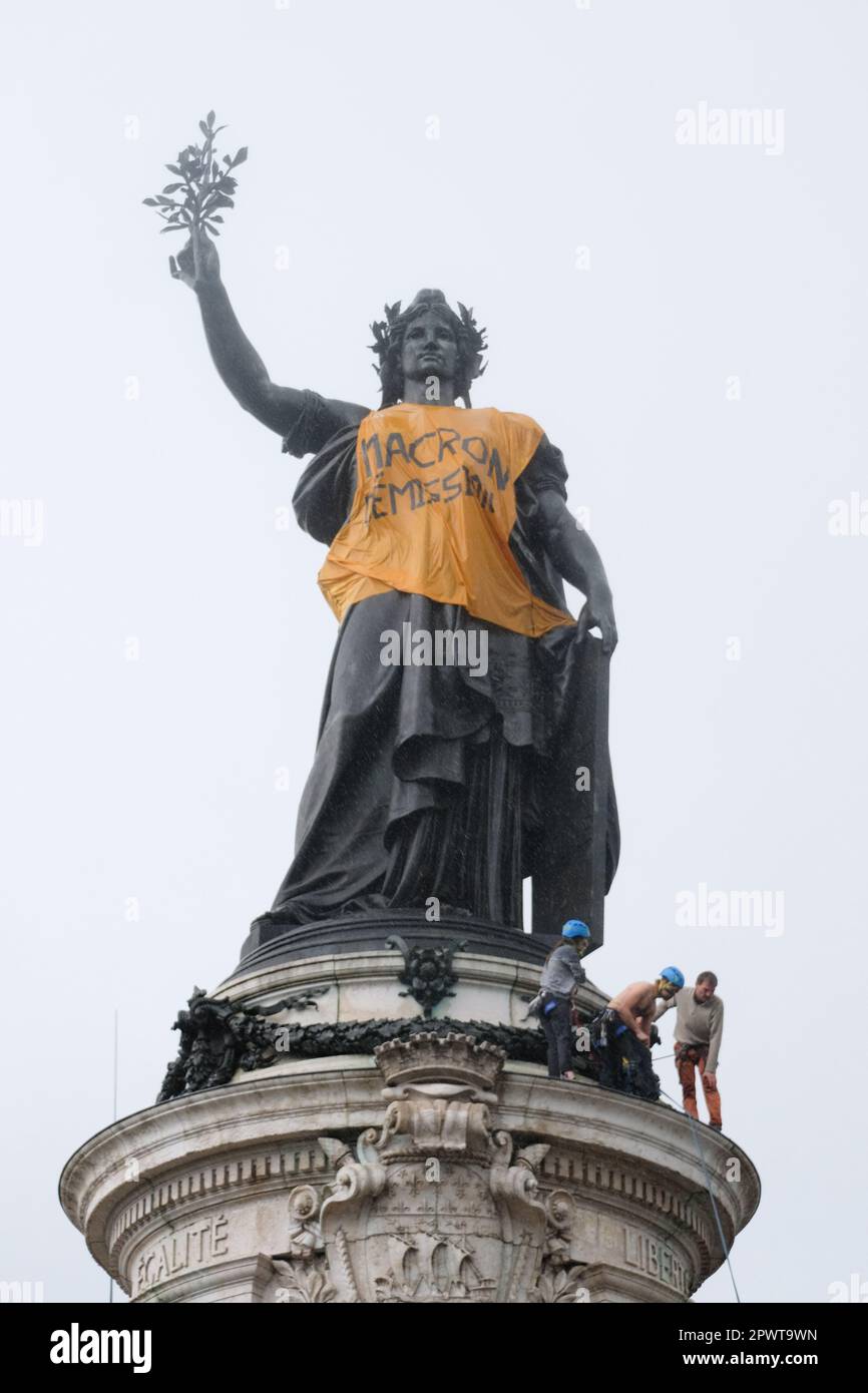 Paris, France. 1 MAY 2023. People climb the statue ‘efige de la ...