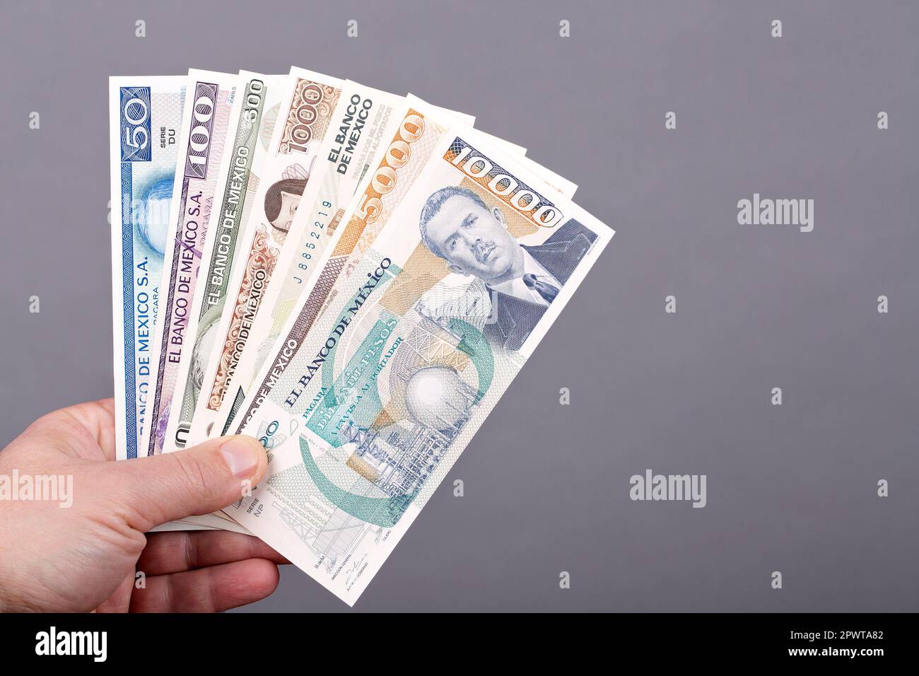 Old Mexican money - Pesos in the hand on a gray background Stock Photo ...