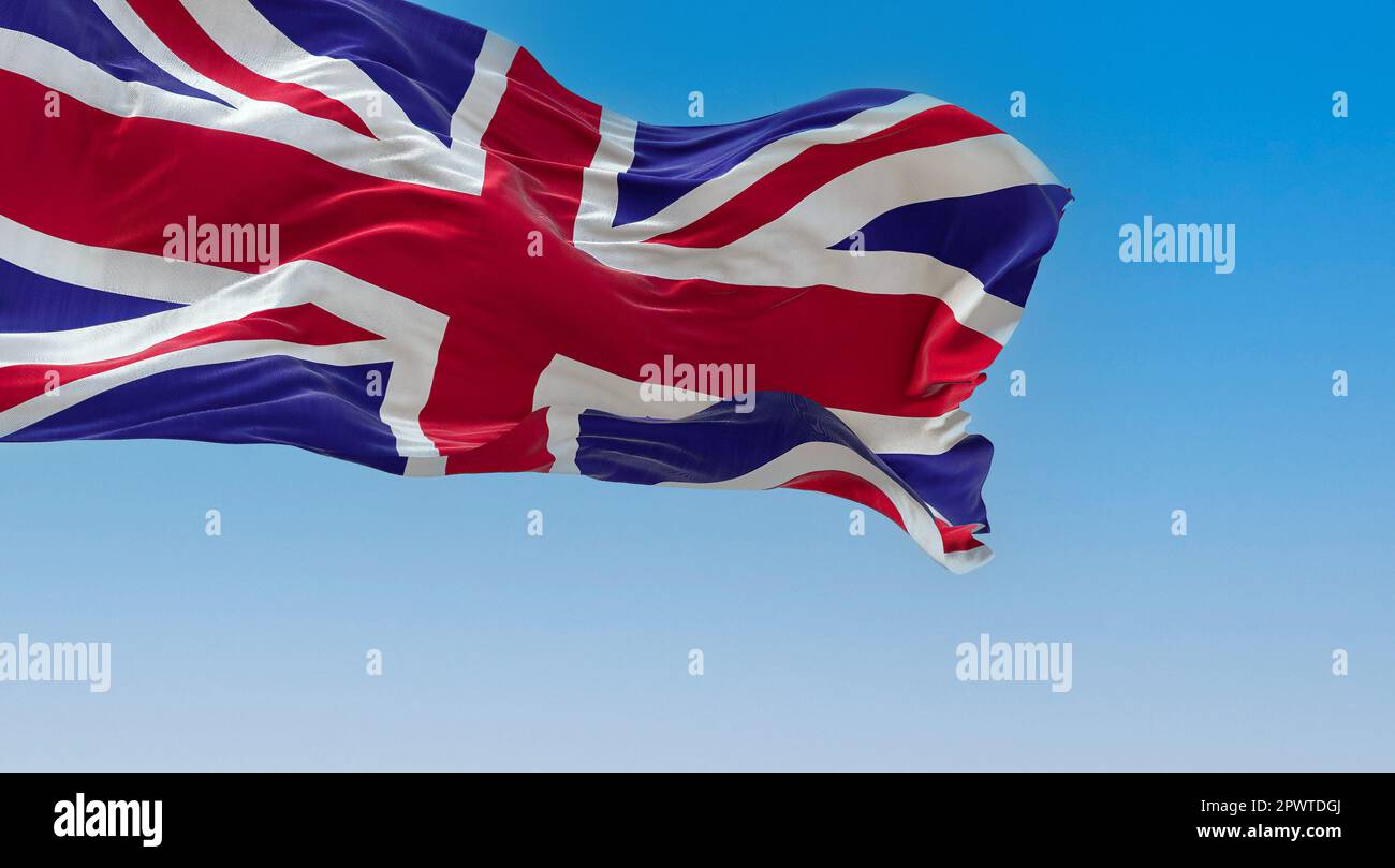 United Kingdom flag waving in the wind on a clear day. Union Jack. Blue ...
