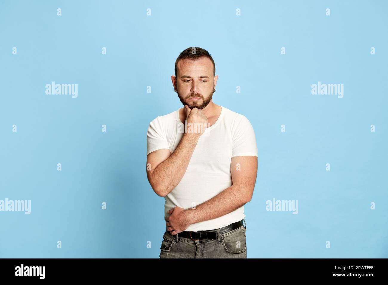 Portrait of bearded man in casual clothes posing, standing with sad ...