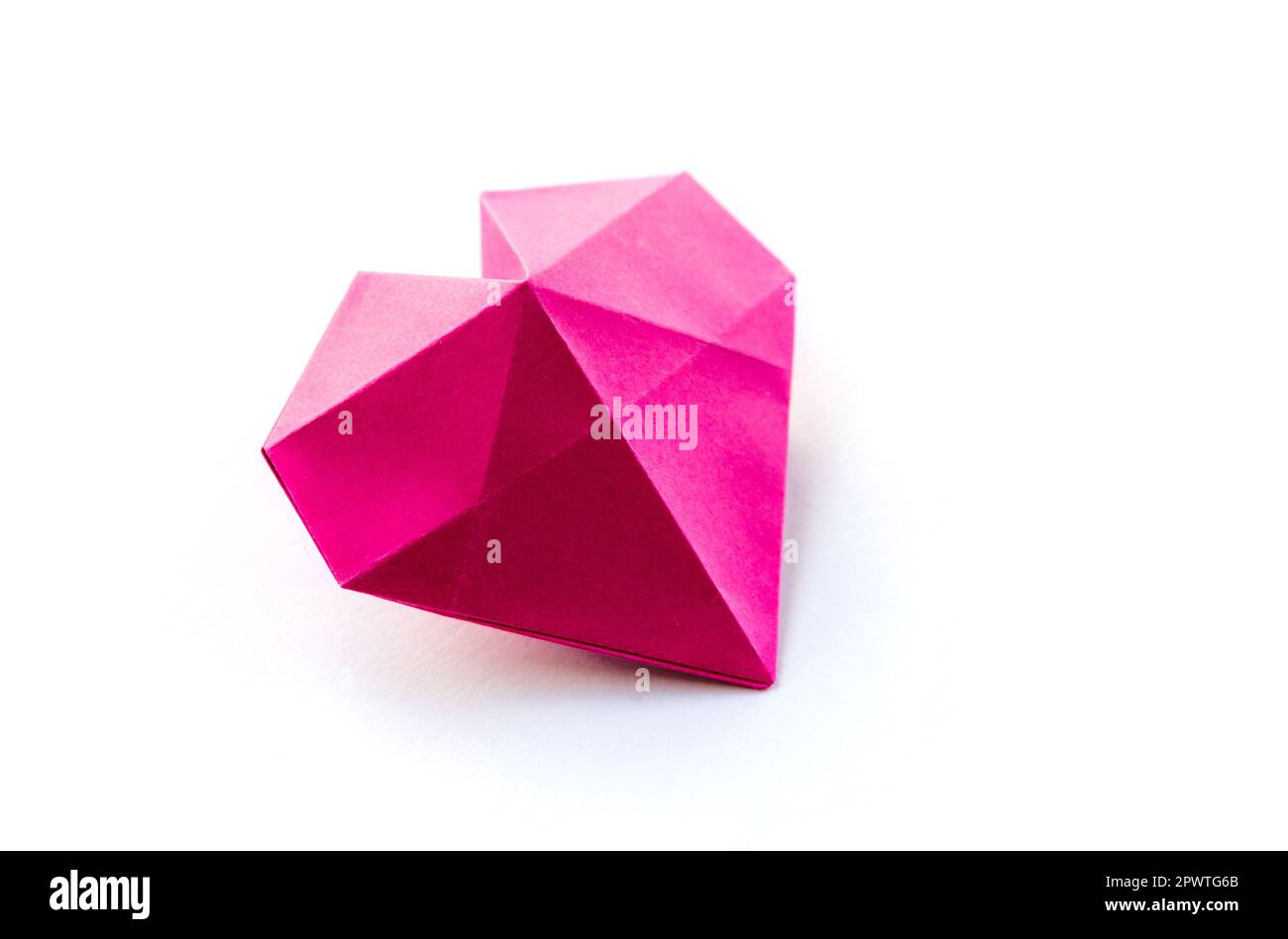 Pink paper heart origami isolated on a blank white background ...