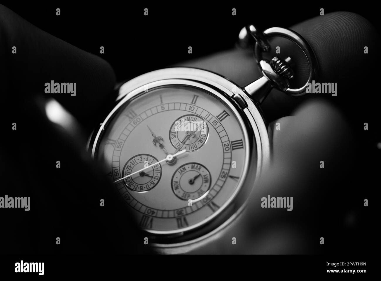 Hand holding a luxury pocket watch. Extreme close up, black and white ...