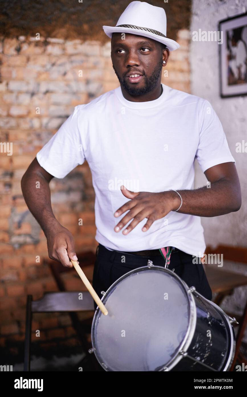 The rhythm of culture. a smiling man playing a hand held drum Stock ...