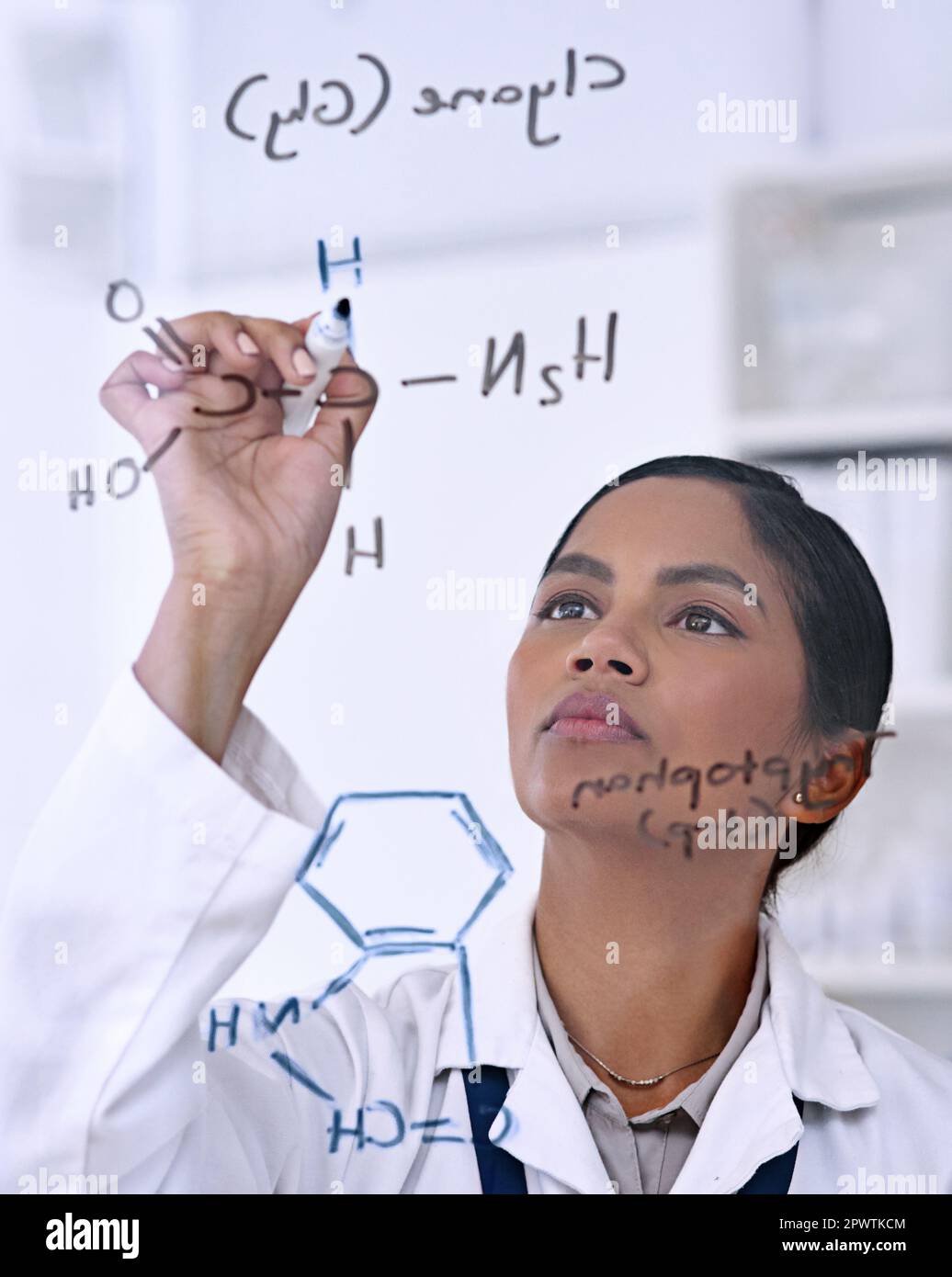 Creating a new formula. an attractive young female scientist working on ...