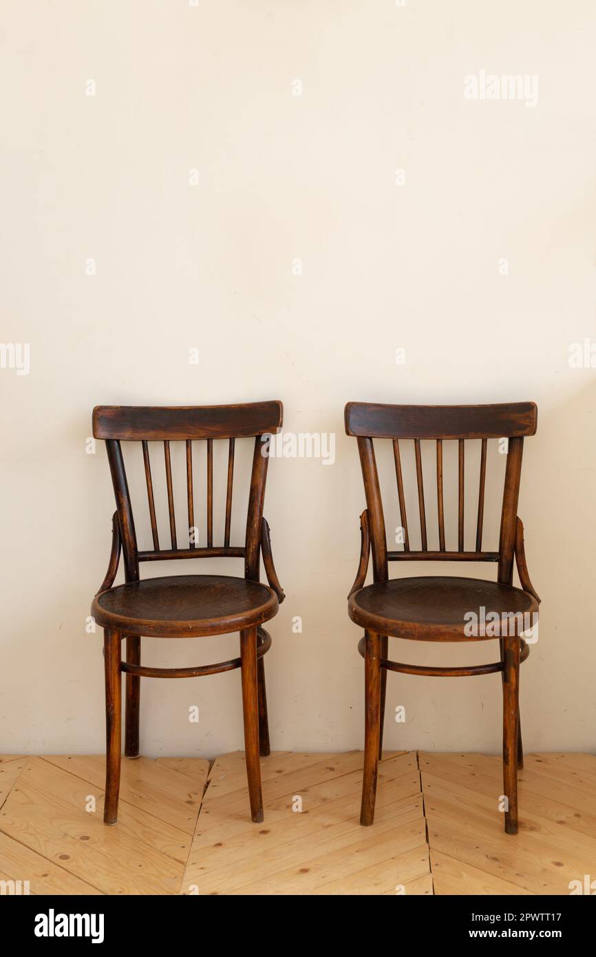Two wooden chairs and white wall background Stock Photo - Alamy