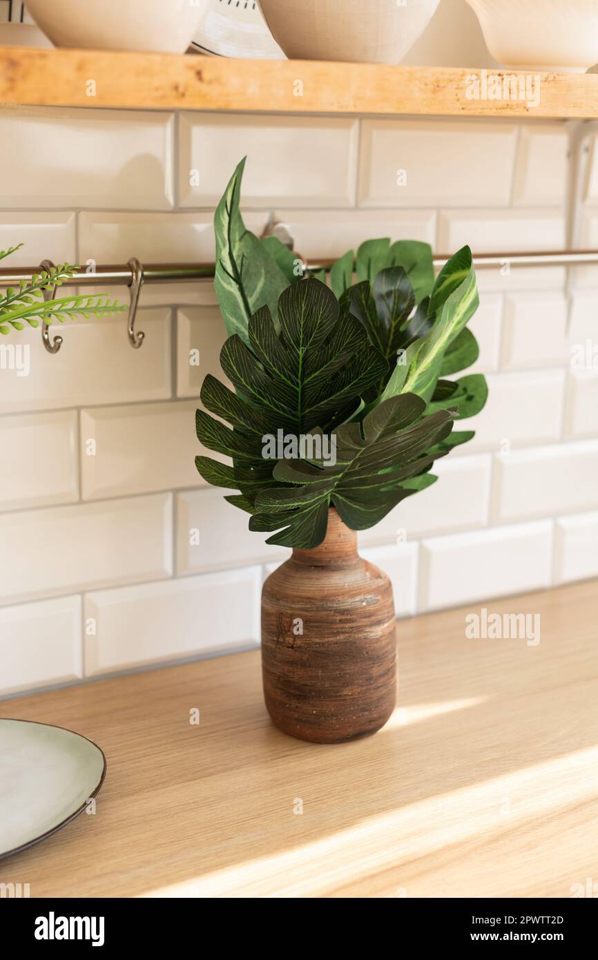 Artificial monstera leaves on a vase in scandinavian kitchen style ...