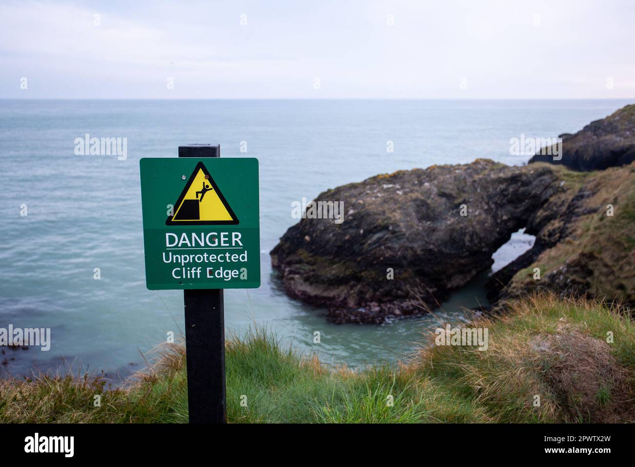 Danger, unprotected cliff edge warning sign with sea background Stock ...