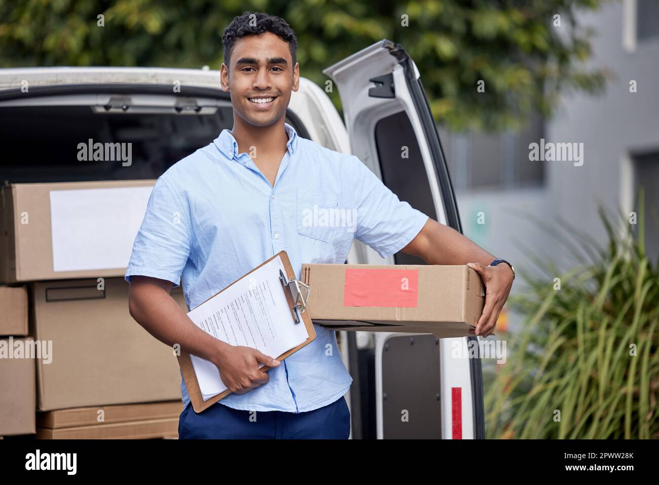 Your stop is next on my list. Portrait of a young delivery man loading ...