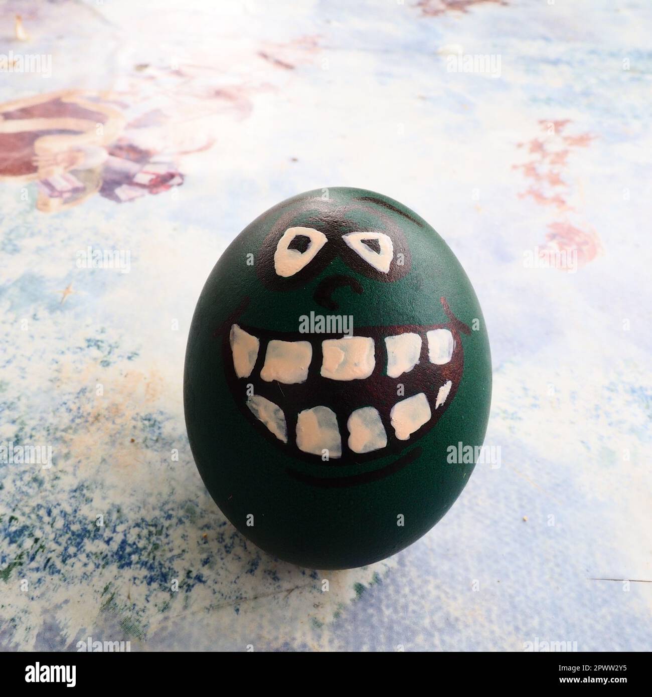 Easter egg dyed green with a painted laughing face. Cool grimace with ...
