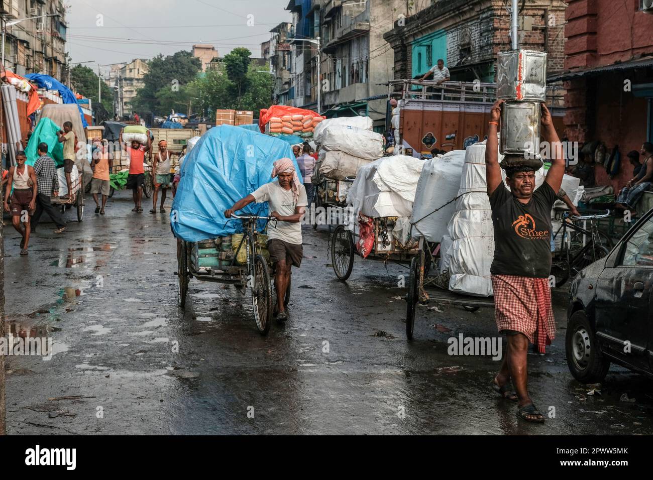 Kolkata, India. 21st Mar, 2023. A labourer seen pushing a loaded ...