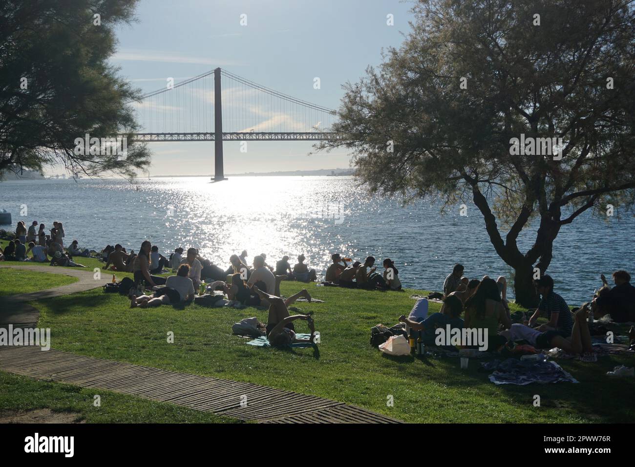 Picknick on the riverside of Tagus in Cacilhas. In the back Ponte 25 de ...