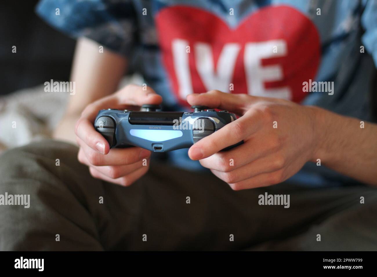 Blue video Game controller in Action, Young man playing video games on ...