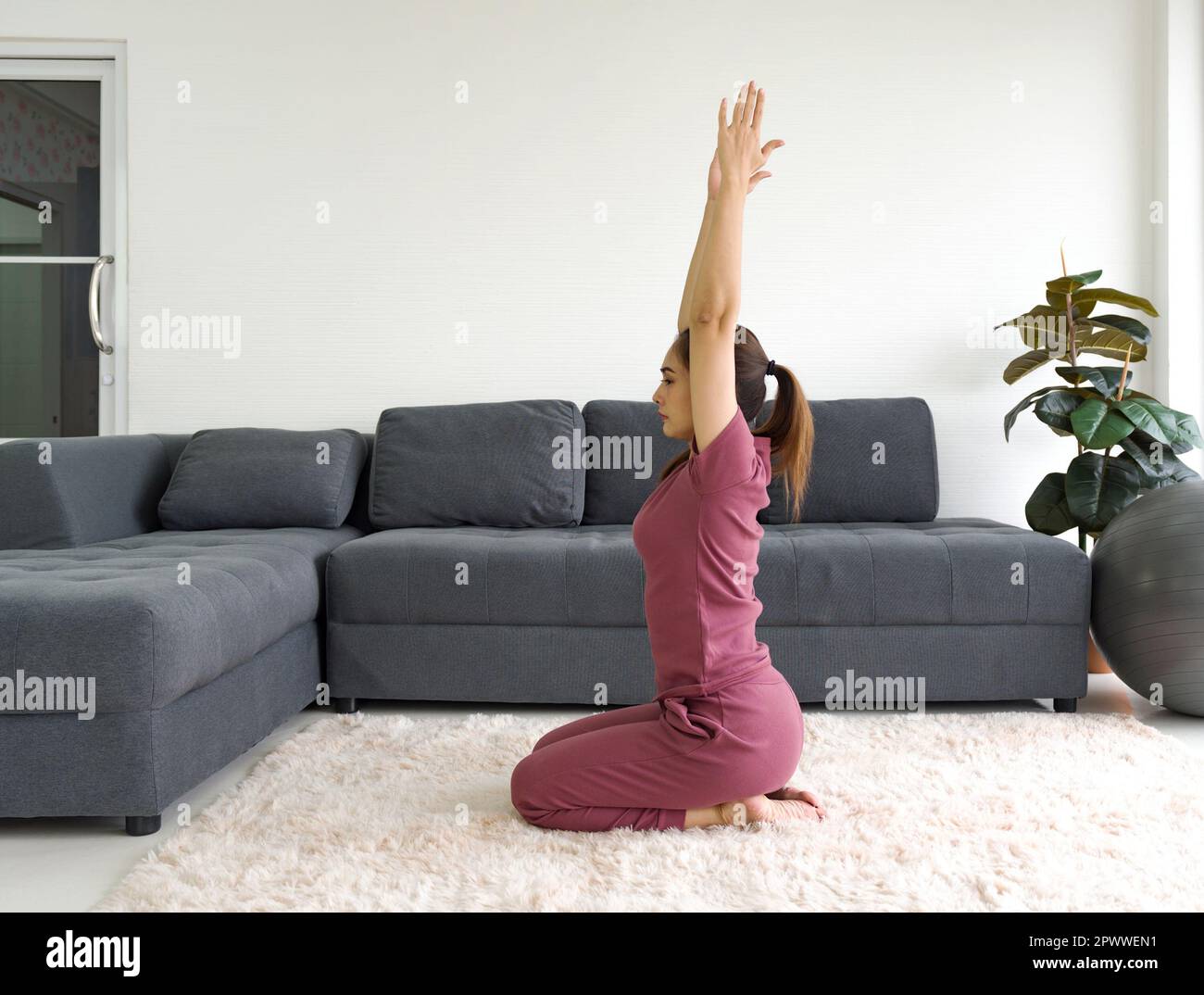 Asian housewife doing the diamond pose exercise during home workout ...