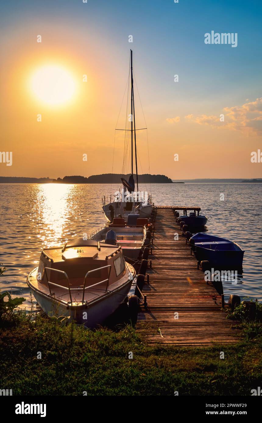 Sailing yacht and jetty in the beautiful lake. Empty wooden jetty with ...