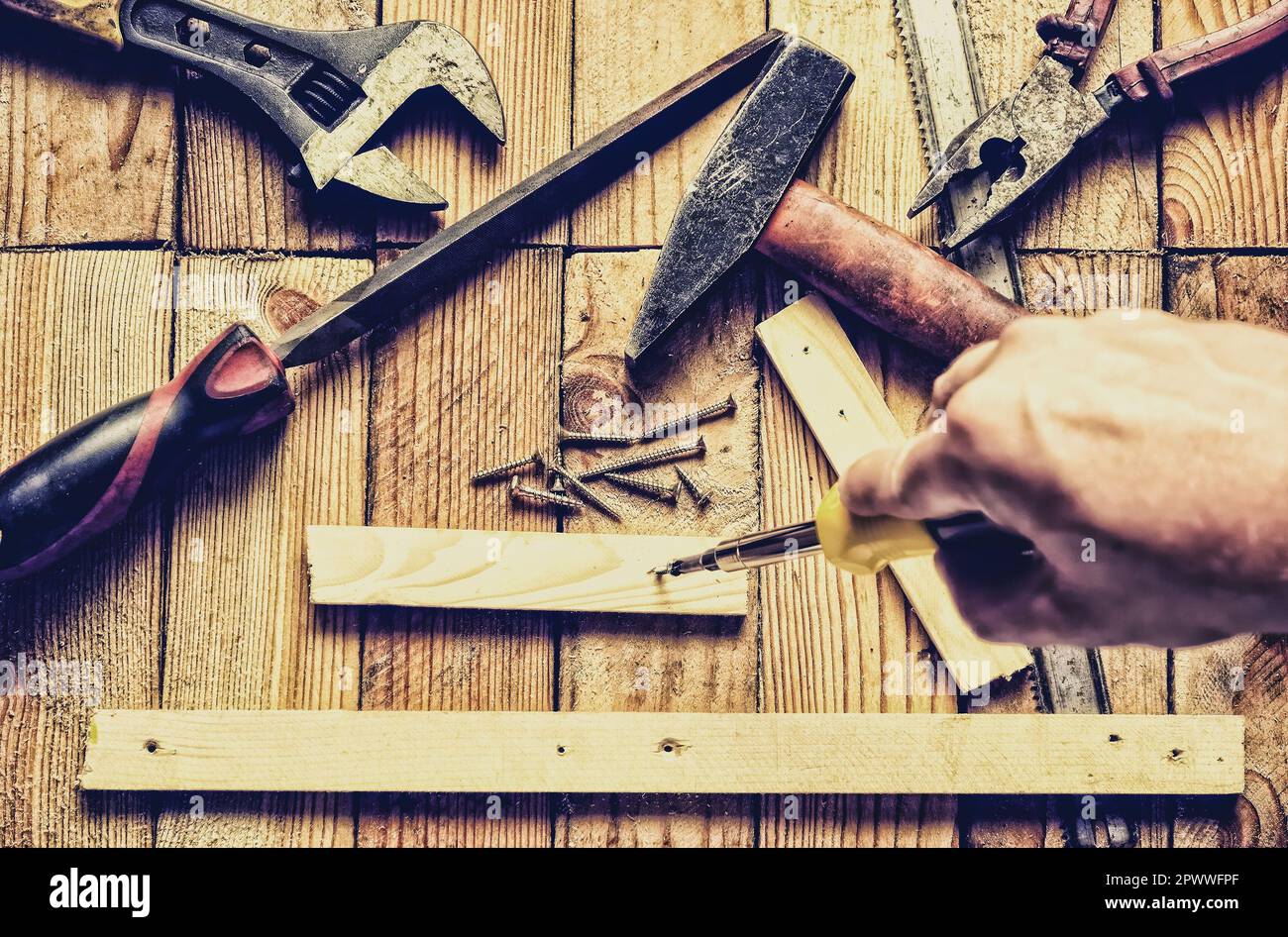 Hand holding tool in the workshop. Screwdriver, flat file, pliers ...
