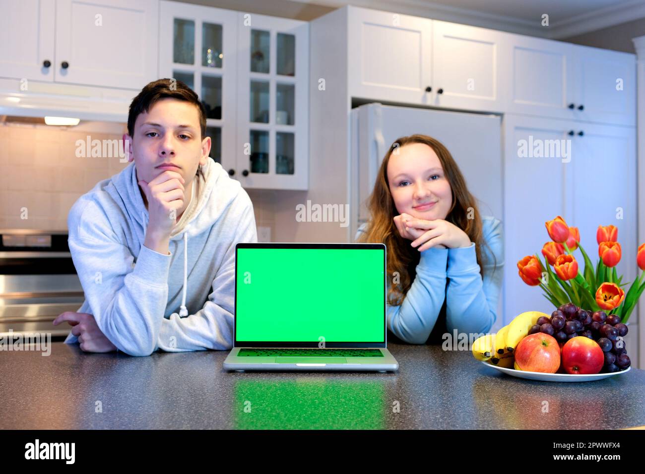 teenagers near laptop with green screen chromakey in kitchen ...