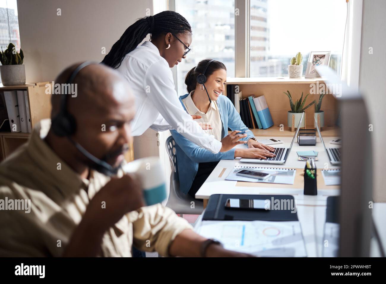 Fueling the engine of success. two businesswomen using a headset and ...