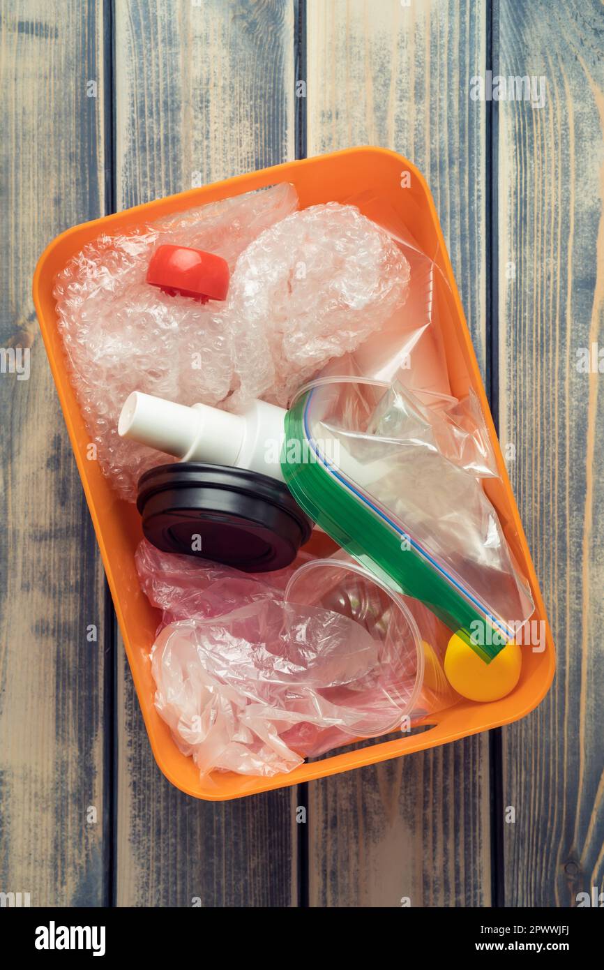 Vertical orange plastic container box full of plastic, polycarbonate ...