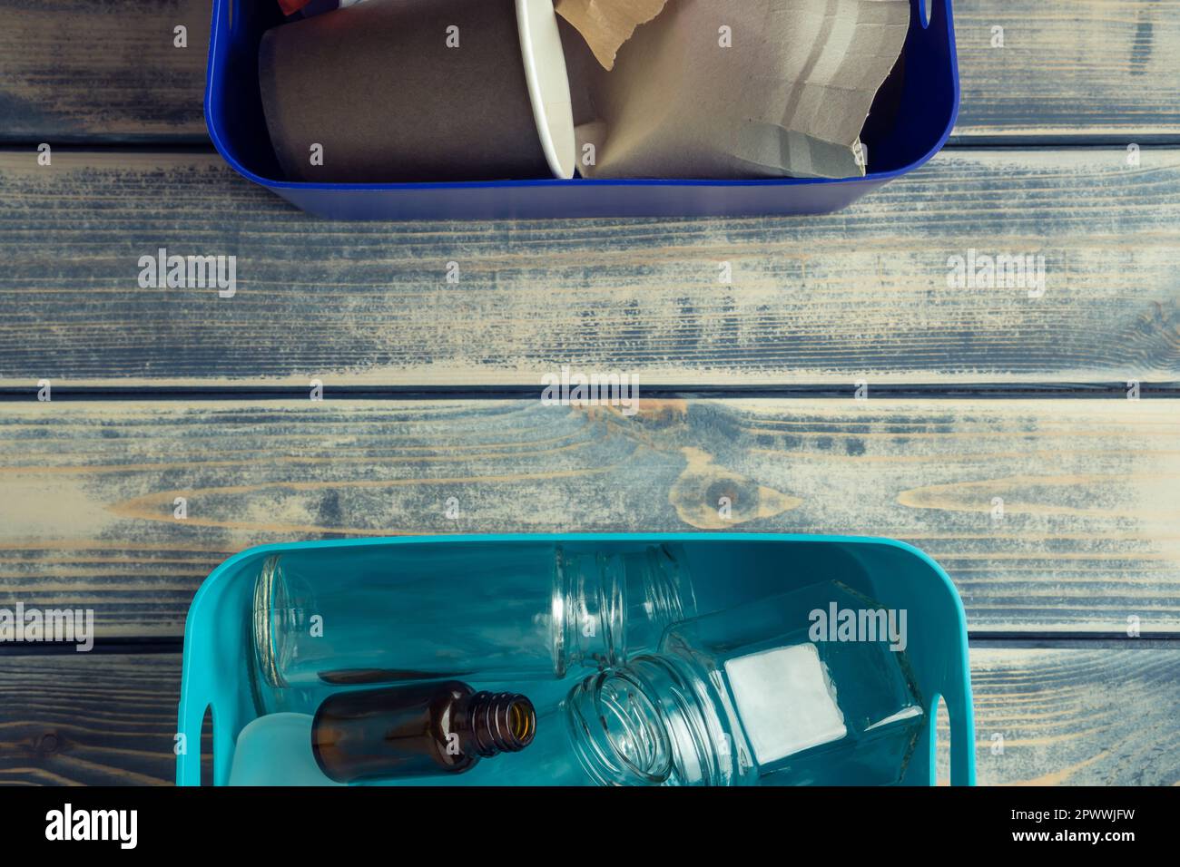 Two halves of containers with waste, trash on wooden table background ...