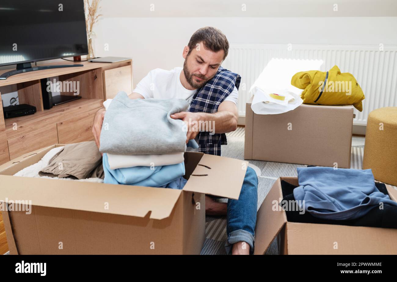 Man packing his clothes, moving house concept Stock Photo - Alamy