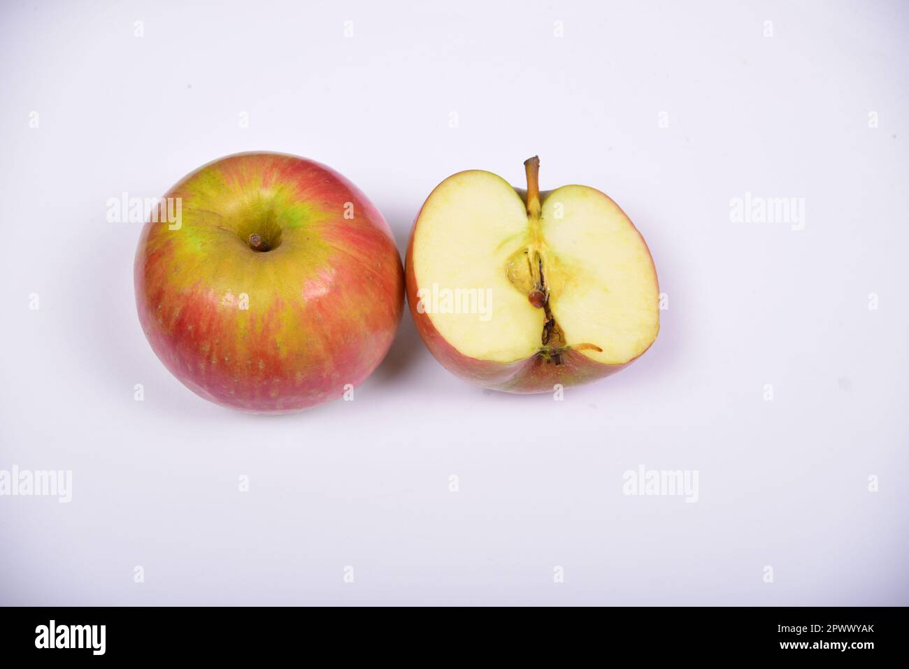 full red apple and half sliced on a plain background Stock Photo - Alamy