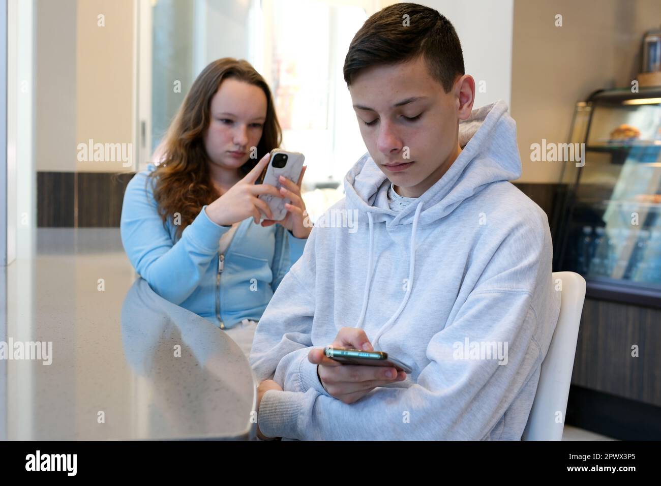 Two teenagers phones cafe hi-res stock photography and images - Alamy