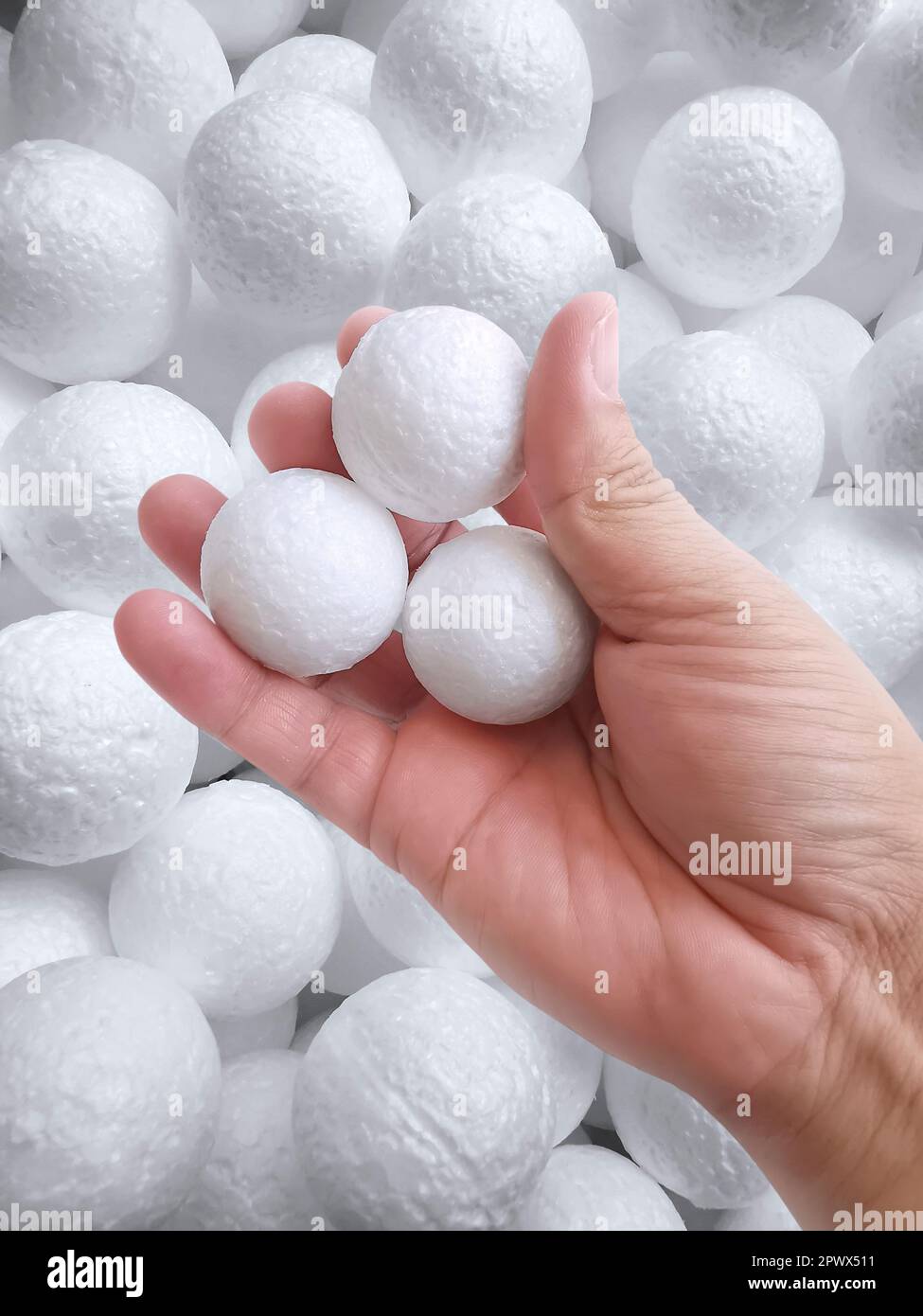 Hand holding white polystyrene foam beads ball drop from Styrofoam ...