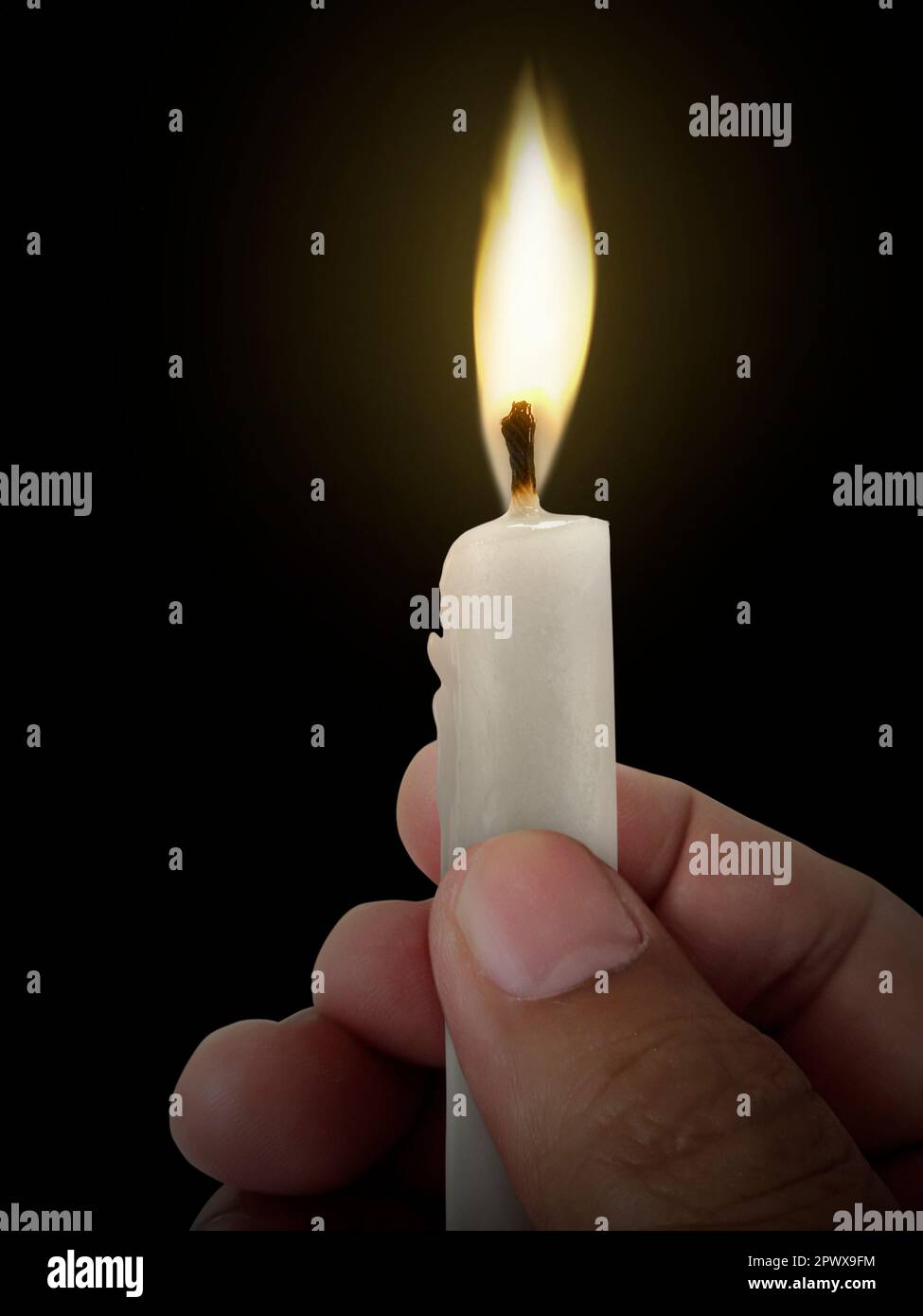 Male hands holding a burning candle in the dark Stock Photo - Alamy