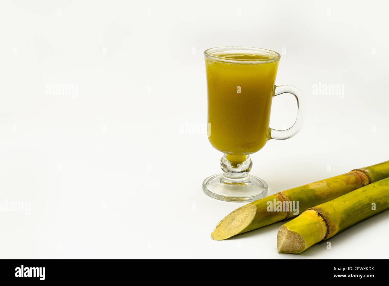 Fresh squeezed sugar cane juice with fresh cane sliced isolated on ...