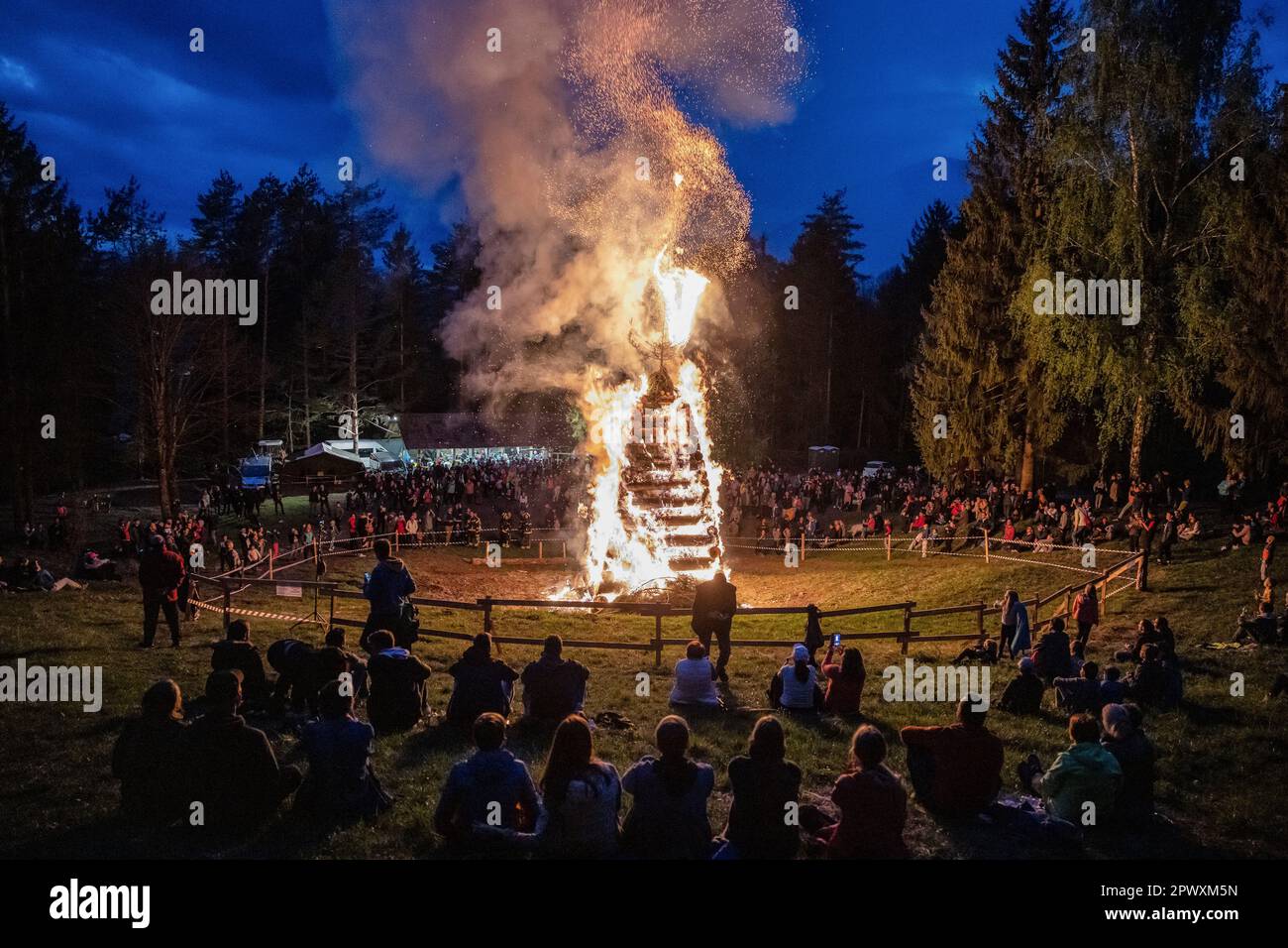 People sit by a bonfire burning in Krize. On the eve before May 1st ...