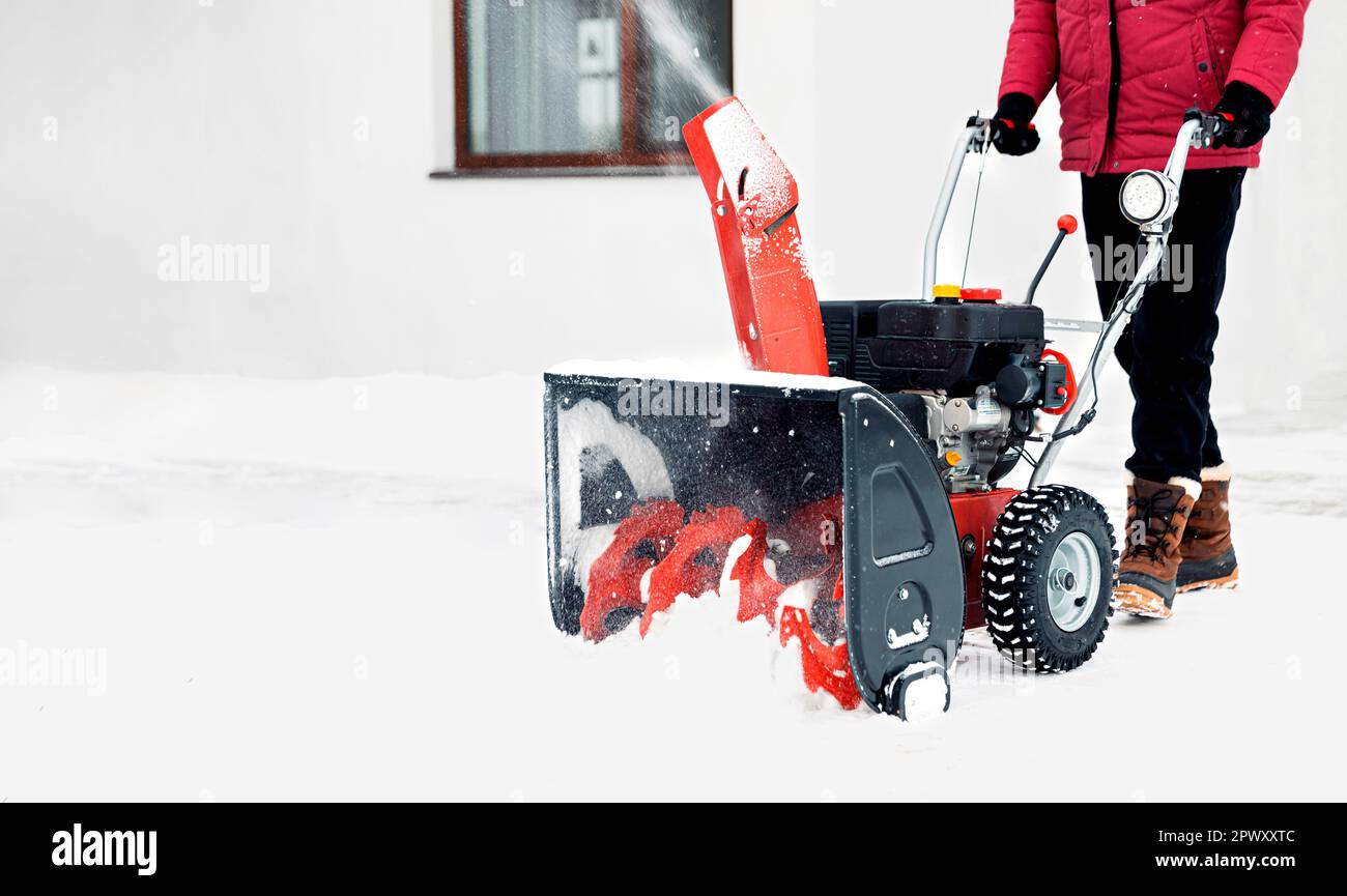 Snow blower powered by gasoline in action. Man outdoor in front of ...