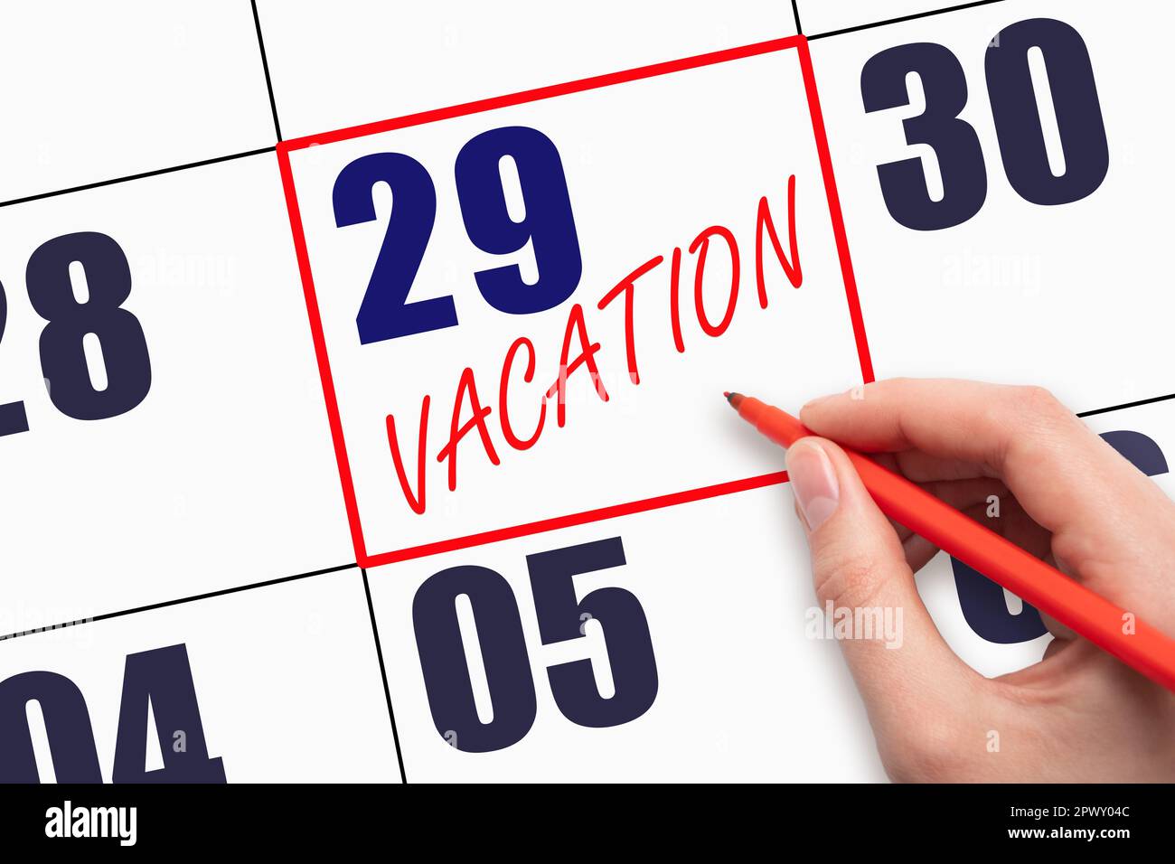 29th day of the month. Hand writing text VACATION on calendar date ...