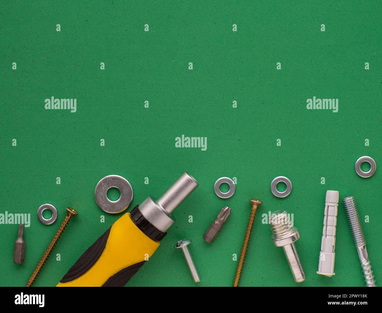 Green background with hand tools, metal fasteners and fittings ...