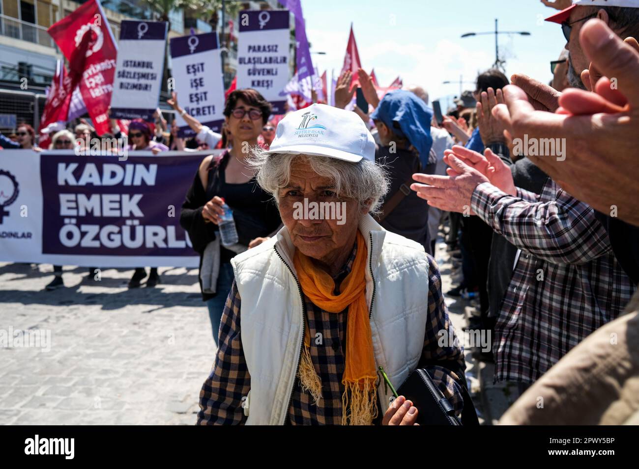 Izmir, Turkey. 01st May, 2023. A woman walks among people clapping ...