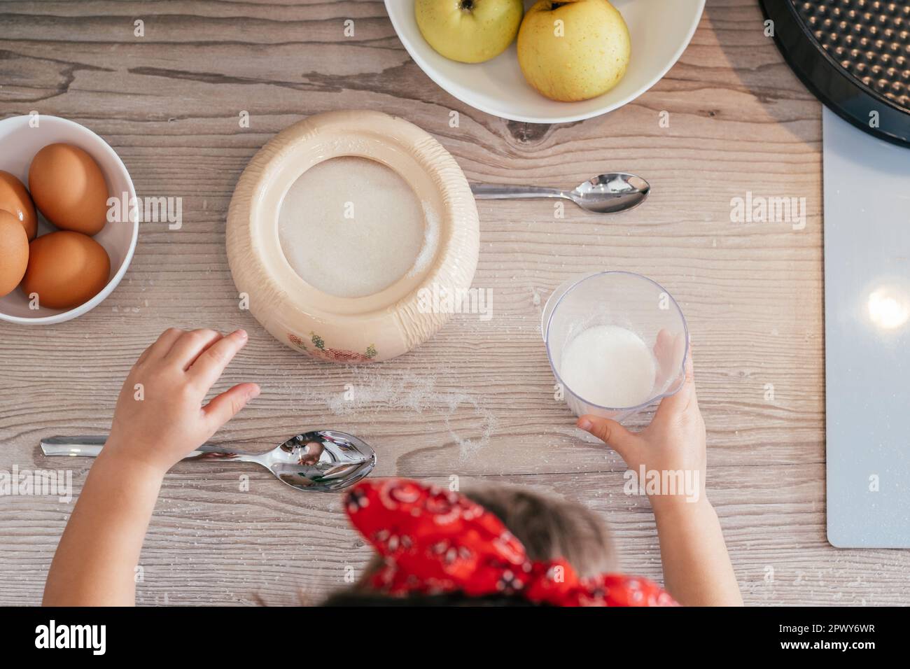 Hands of little girl in red headband bake apple pie in kitchen. Child ...