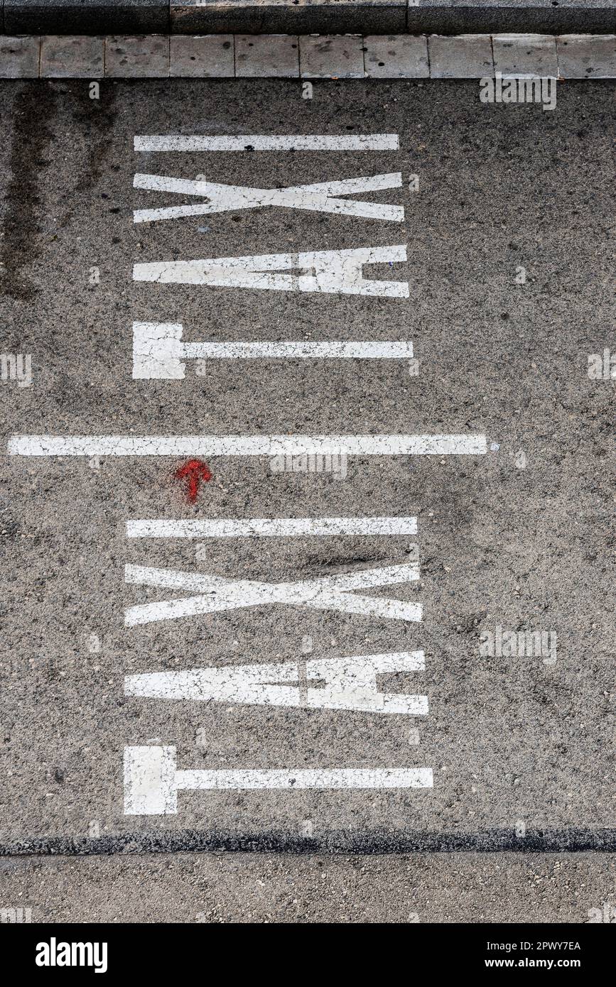 Overview of a taxi lane sign on cracked asphalt Stock Photo - Alamy