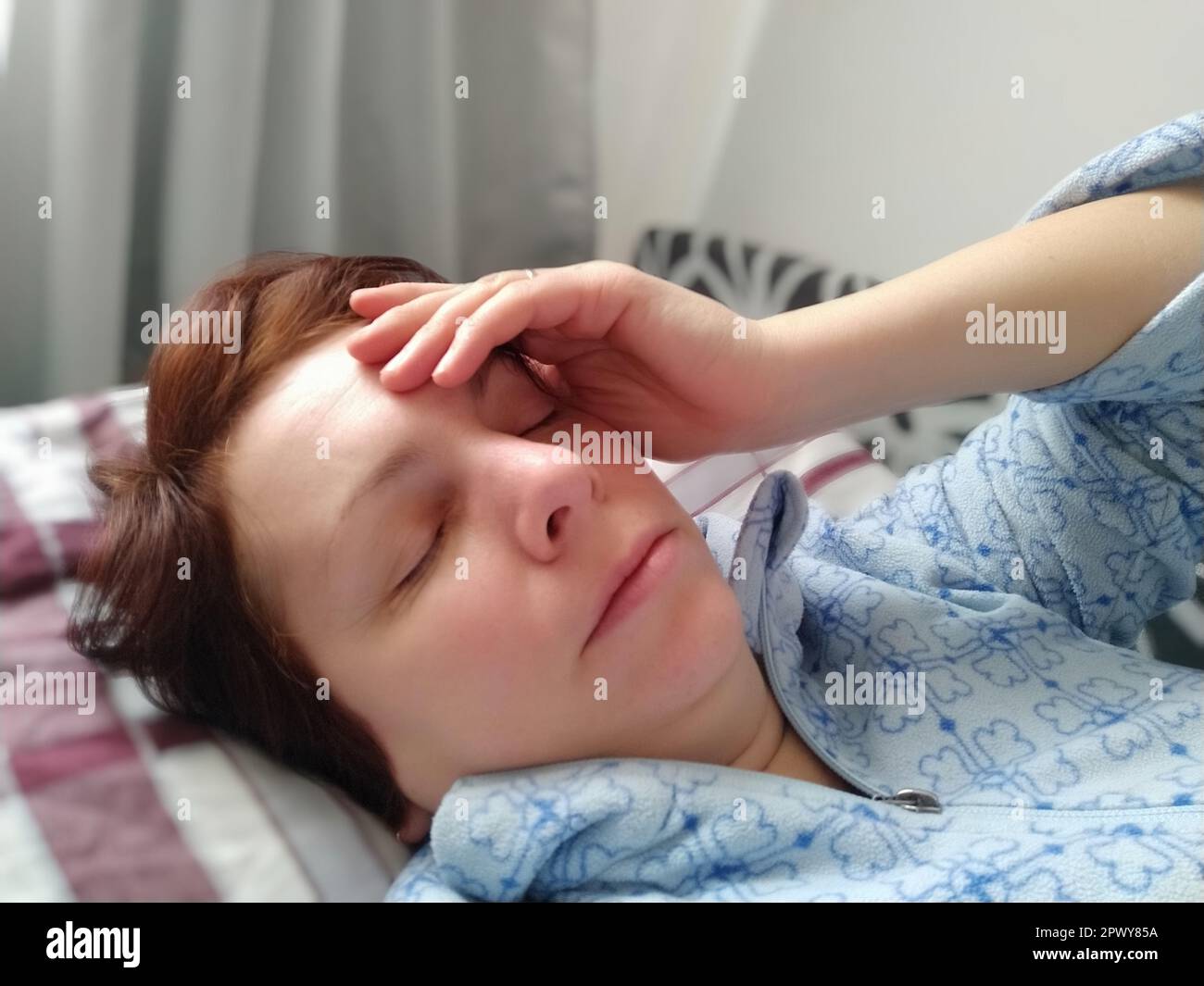 Sick woman in bed. Headache, runny nose and cold. Paleness of the face ...