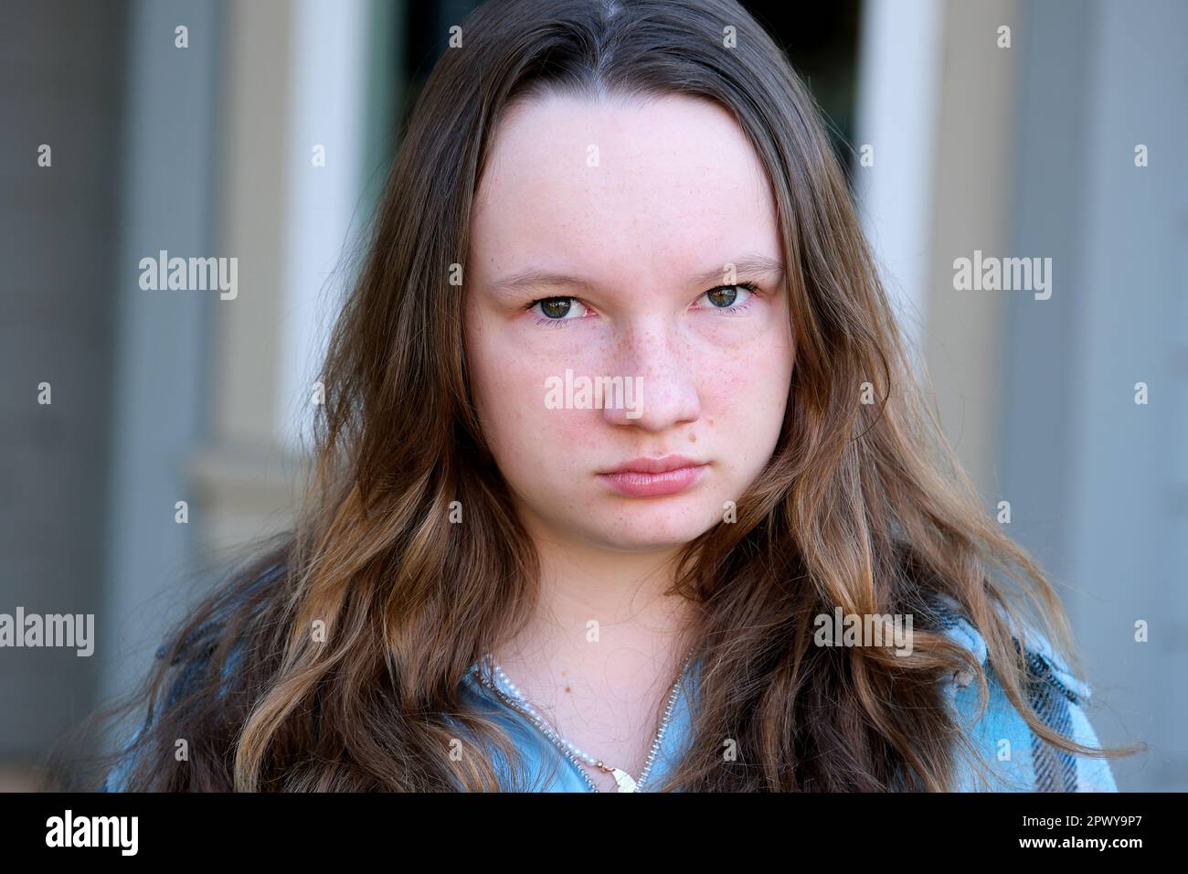 Young beautiful very angry teenager girl wearing blue with brown wavy ...