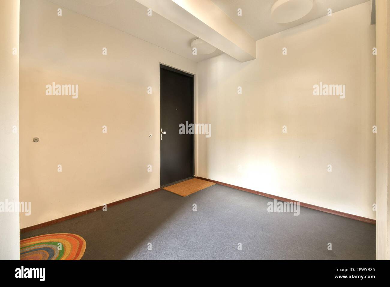 an empty room with a door and rug on the floor in front of the doorway ...