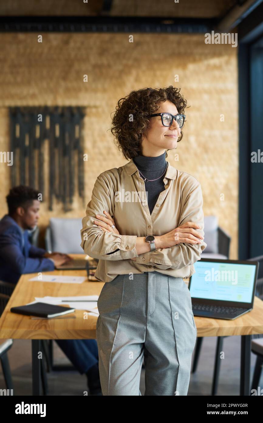 Young pretty business leader in quiet luxury attire looking through ...