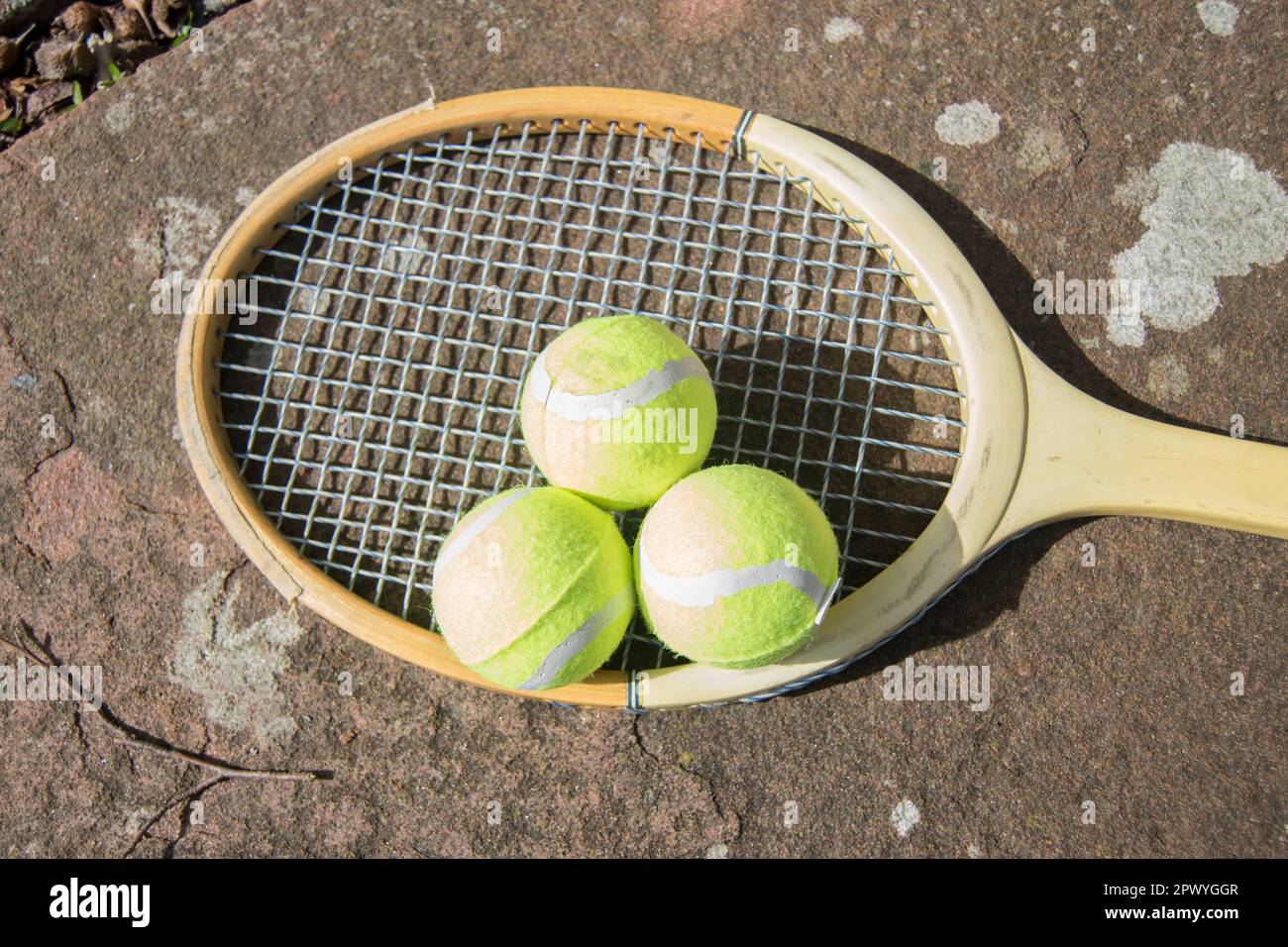 Three tennis balls and vintage racket on the path Stock Photo - Alamy