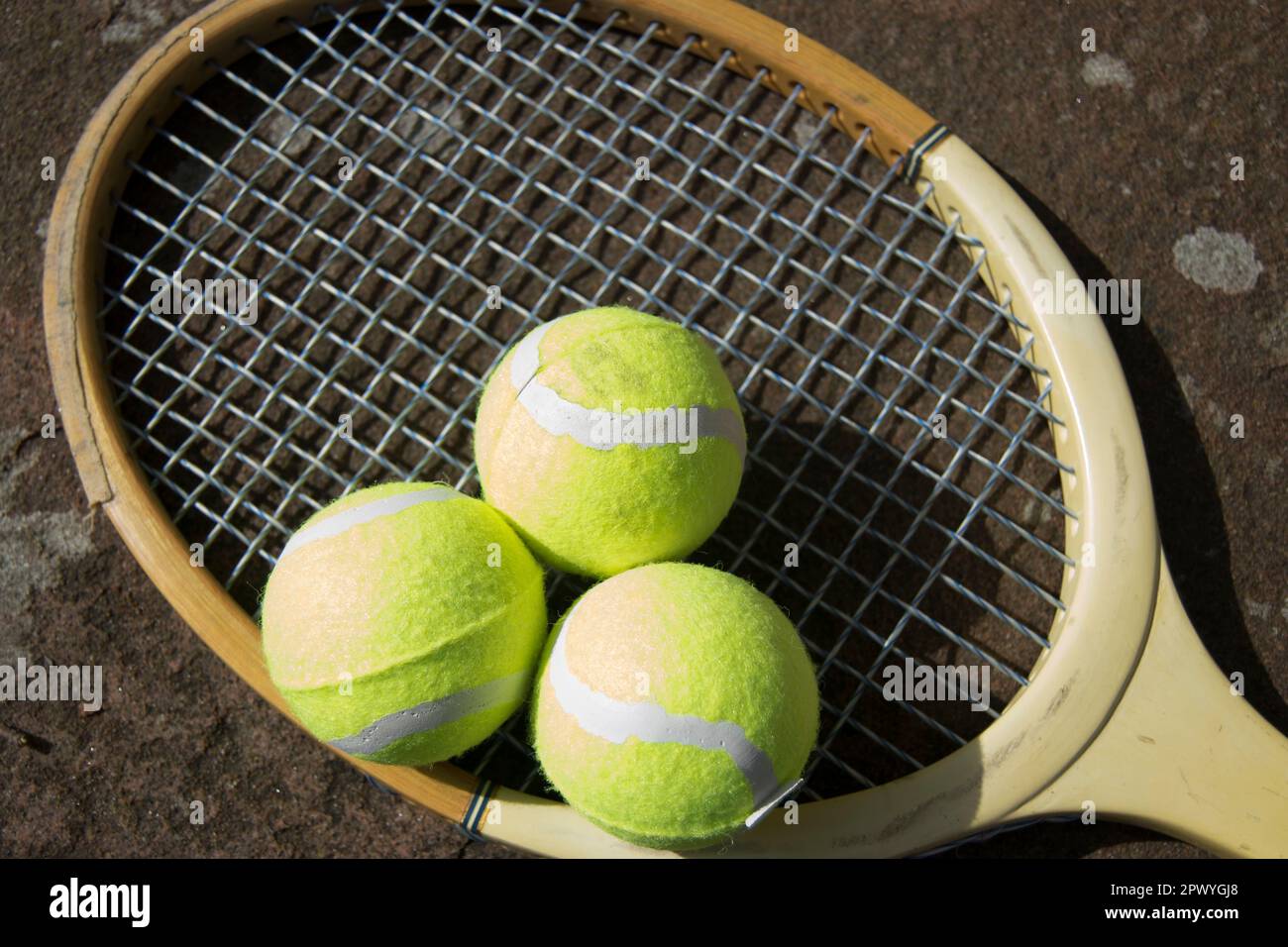 Three tennis balls and vintage racket on the path Stock Photo - Alamy