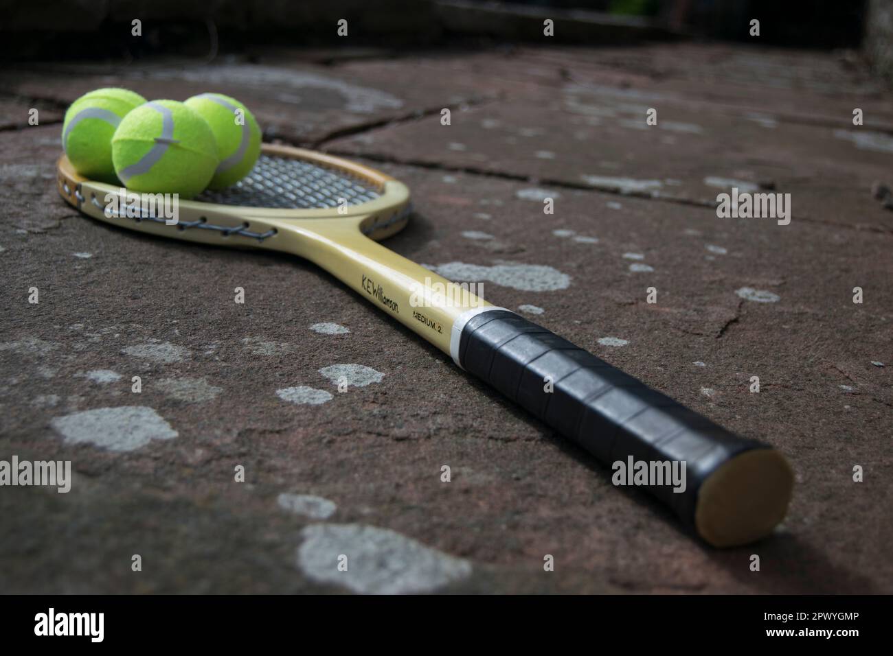 Three tennis balls and vintage racket on the path Stock Photo - Alamy