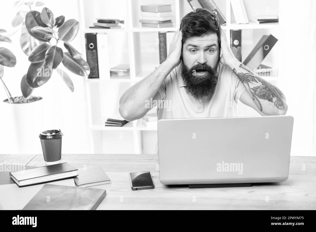 Shocked businessman clutching head staring in laptop at office desk ...