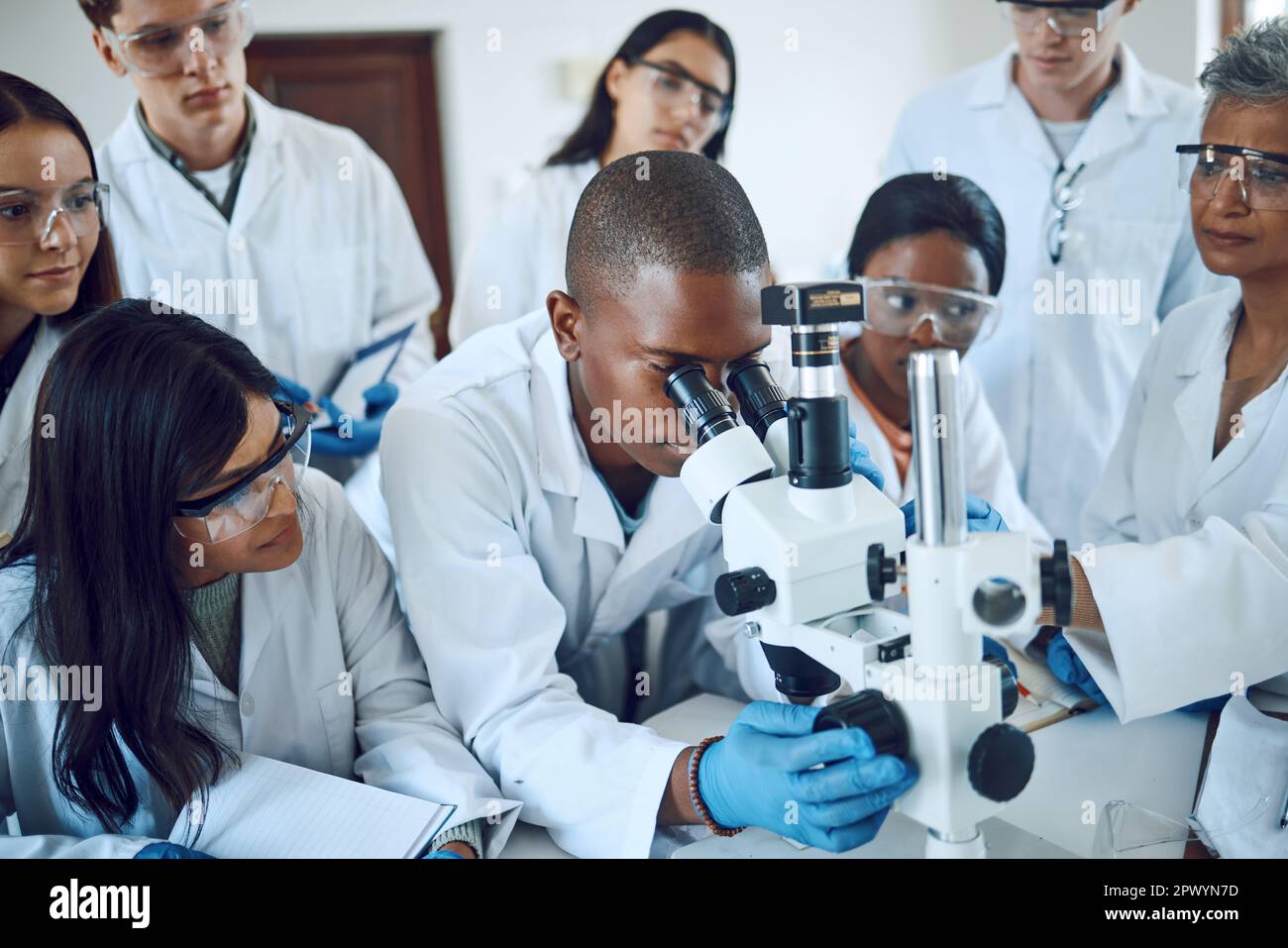 Teamwork, collaboration and group of scientists with microscope for ...