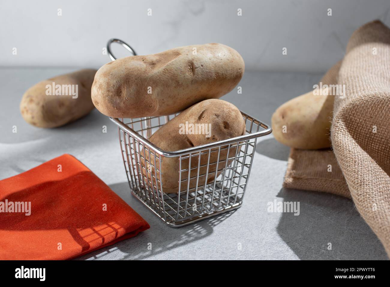 A view of several russet potatoes in a wire rack basket Stock Photo - Alamy