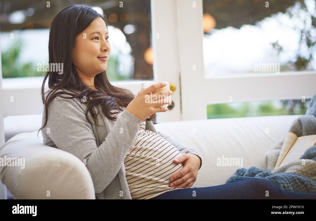 Shes looking forward to the future. an attractive young pregnant woman ...